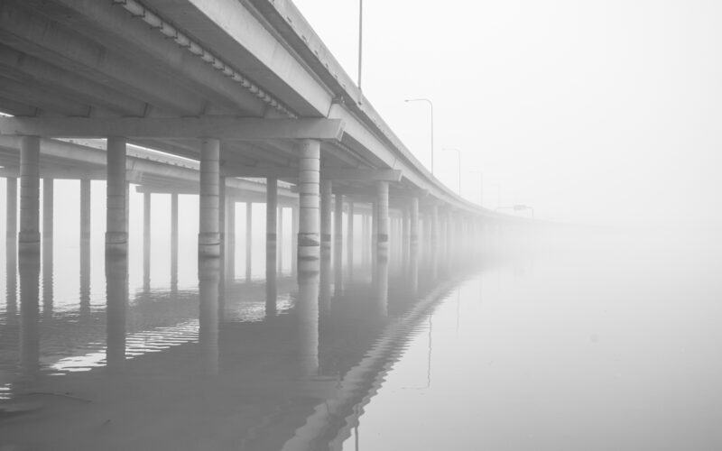 A Bridge In Fog Extending Into The Mysterious White Nothingness